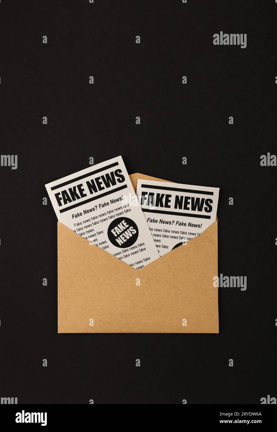Envelope with FAKE NEWS newspapers over black Stock Photo - Alamy