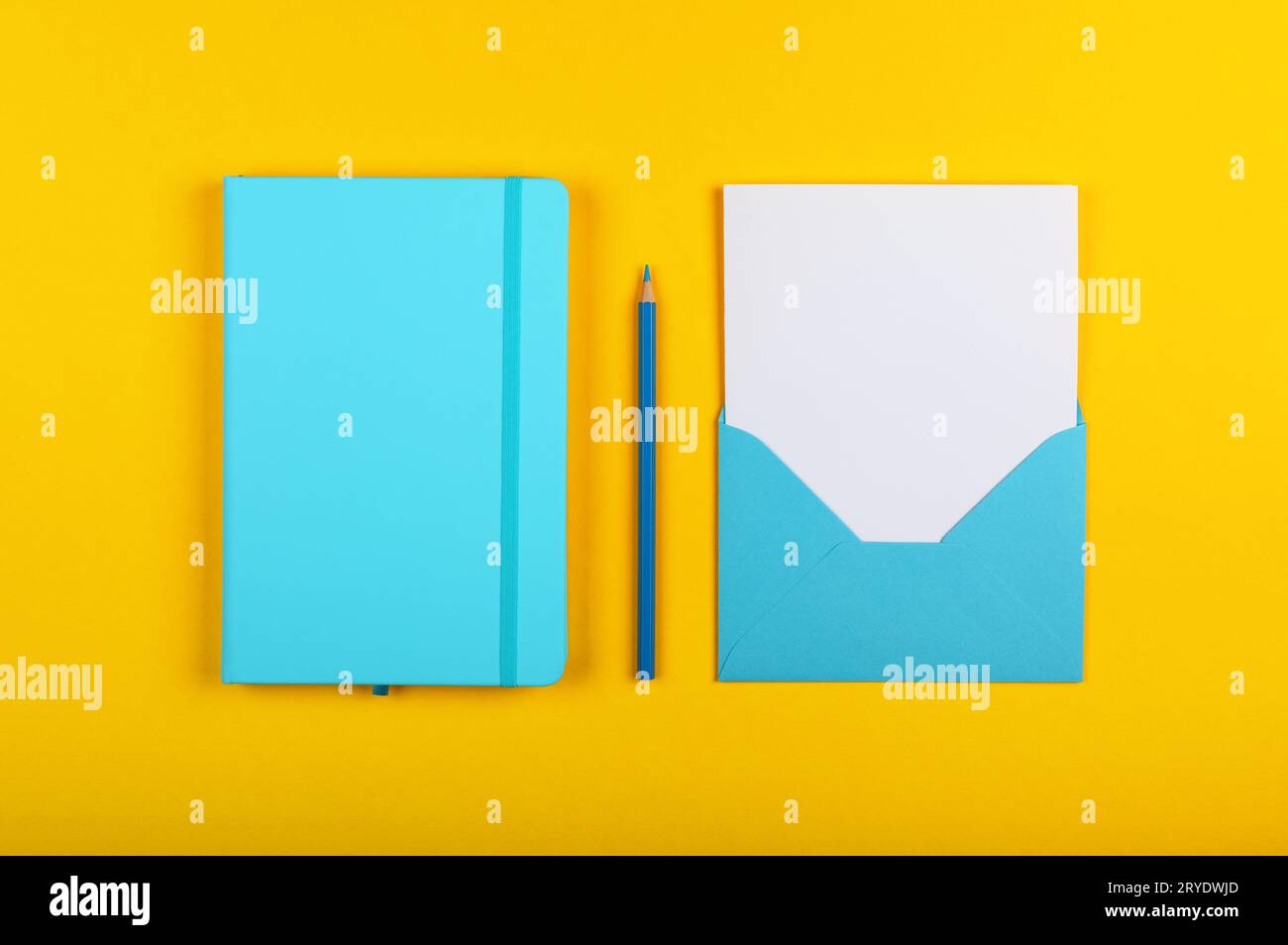 Blue notebook and paper envelope over yellow Stock Photo - Alamy