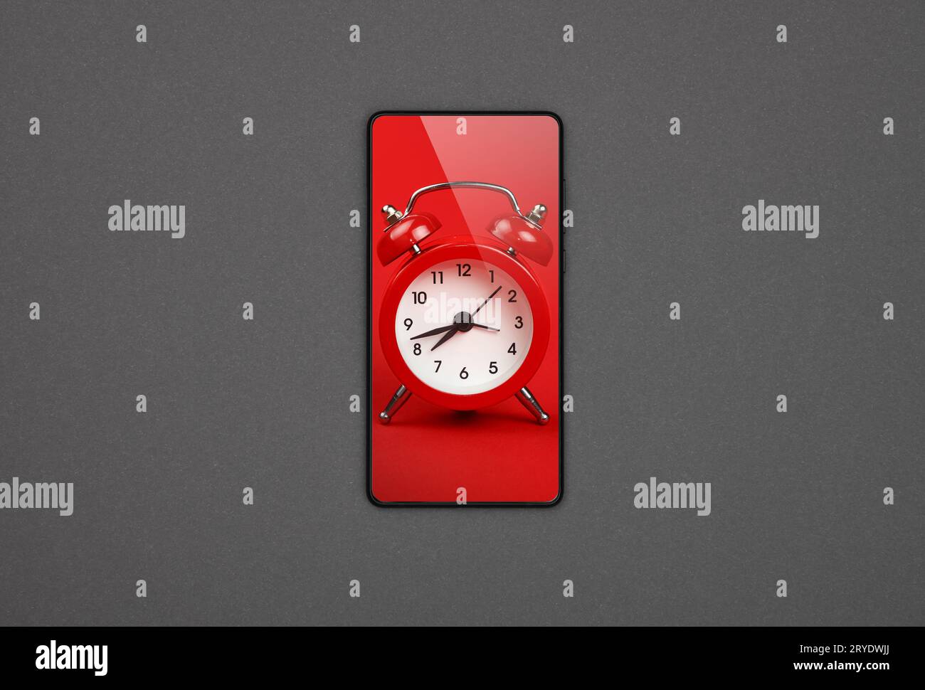Smartphone with red alarm clock screen over grey Stock Photo - Alamy