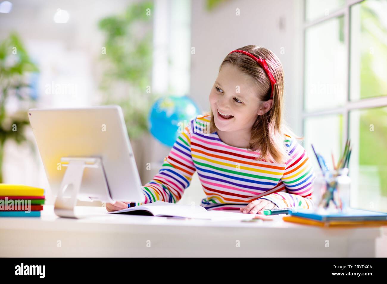 Online remote learning. School kids with computer having video conference chat with teacher and ...