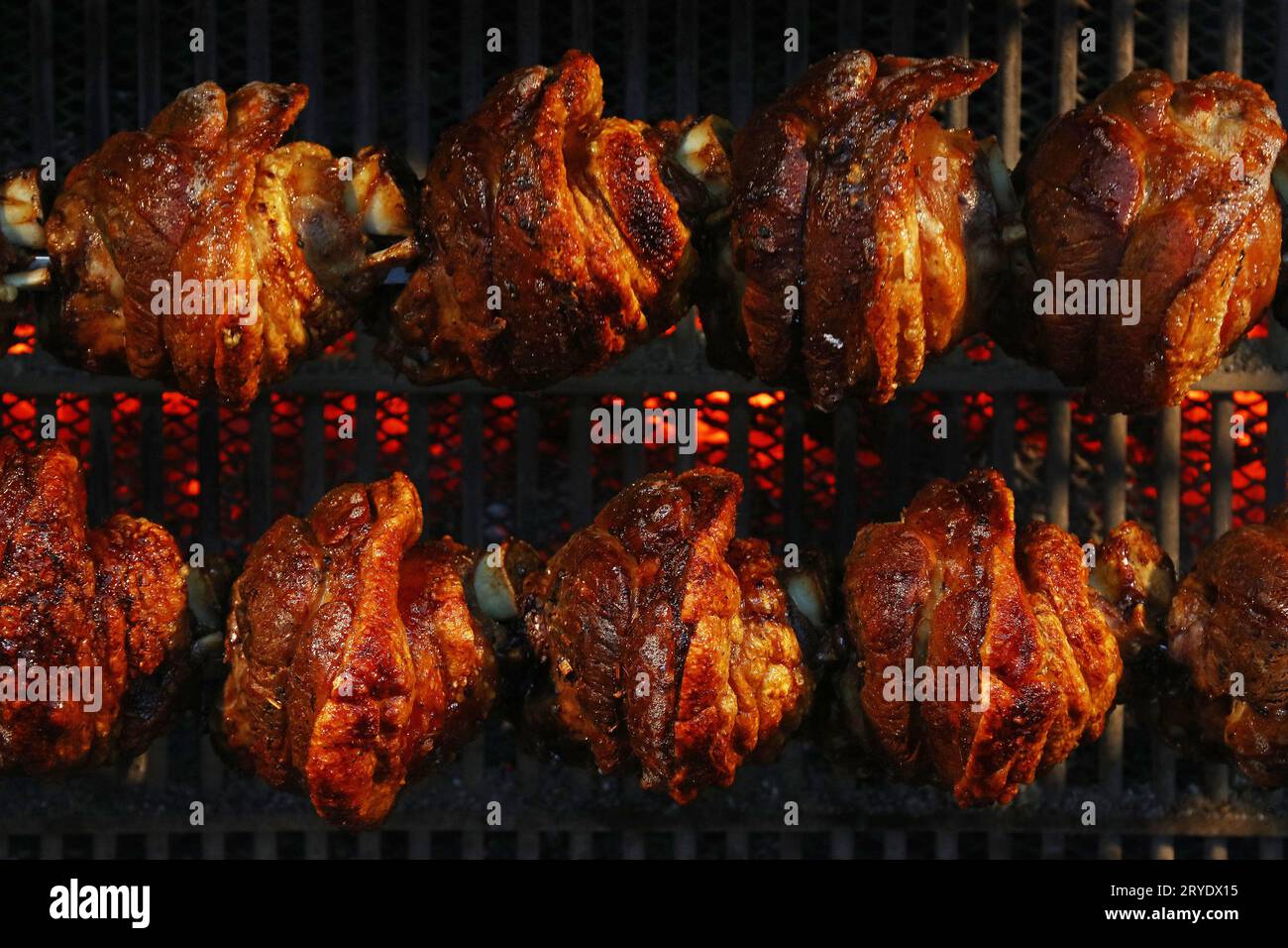 Pork knuckles slowly cooked at rotation grill Stock Photo - Alamy