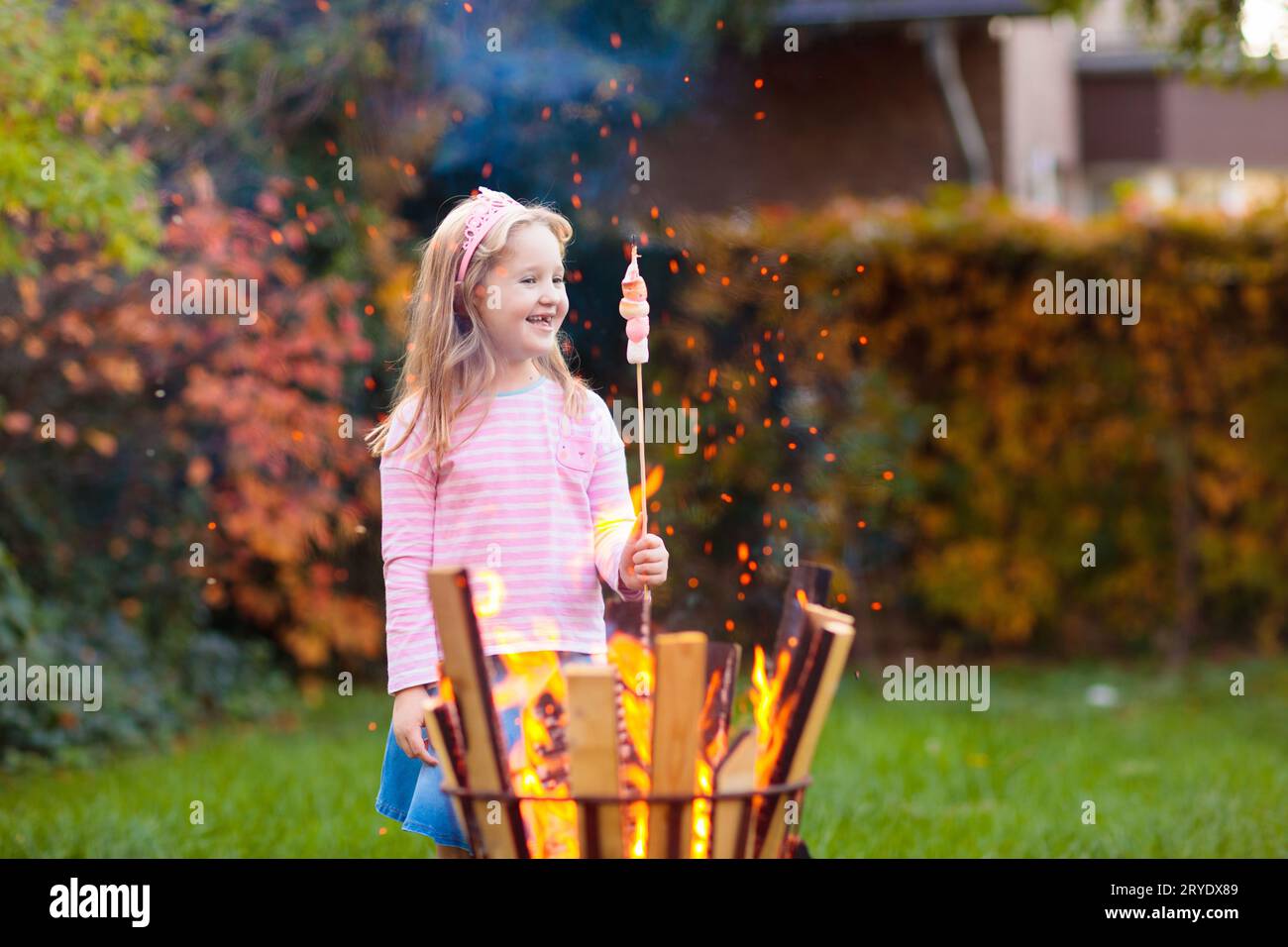 Child with smores at camp fire. Kids roast marshmallow on stick at ...