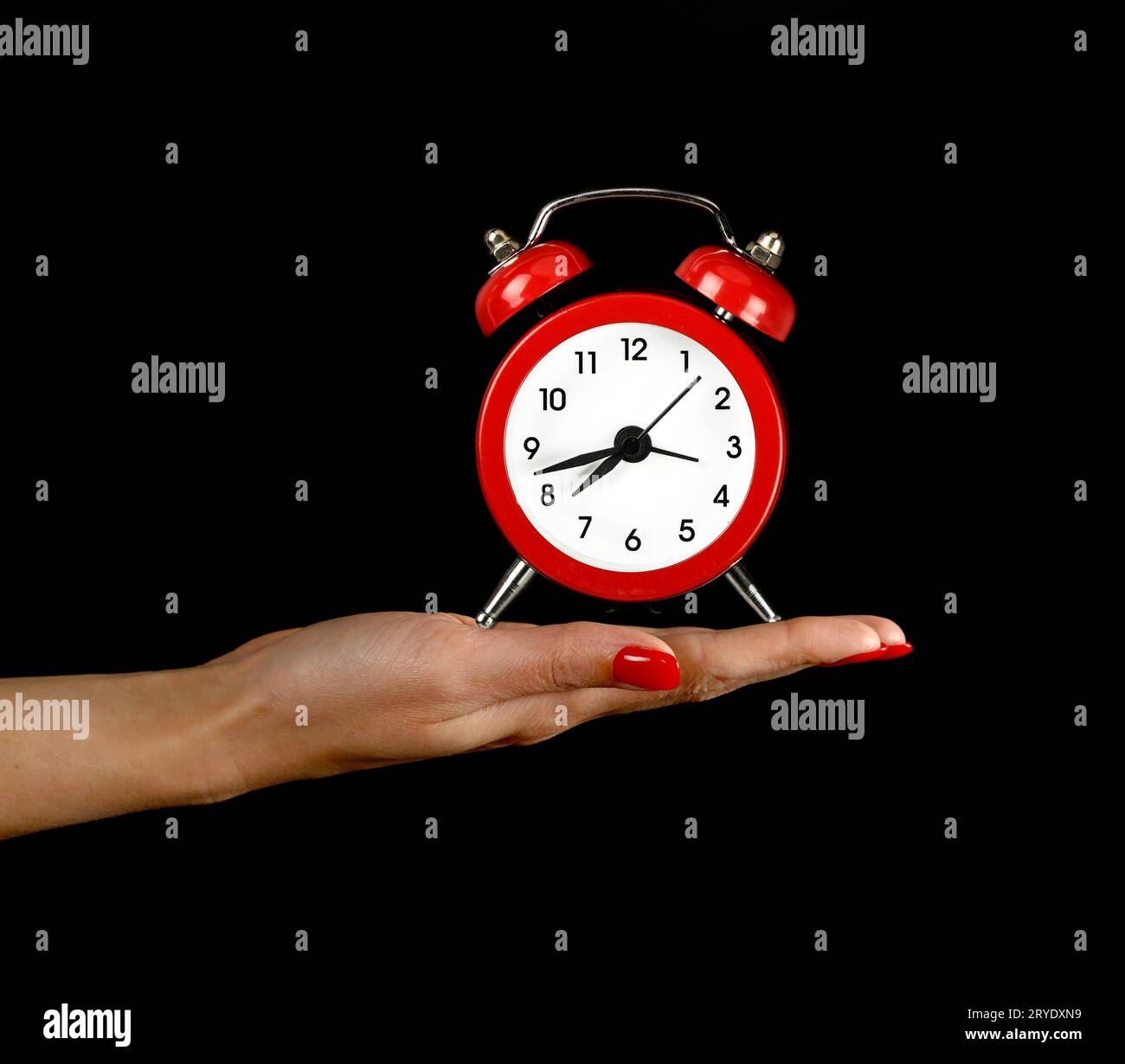 Woman hand palm presenting red clock over black Stock Photo - Alamy