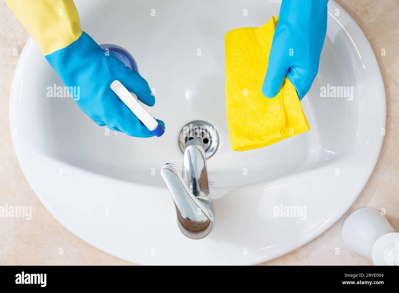 Hands with protection gloves cleaning a bathroom. Disinfection or ...