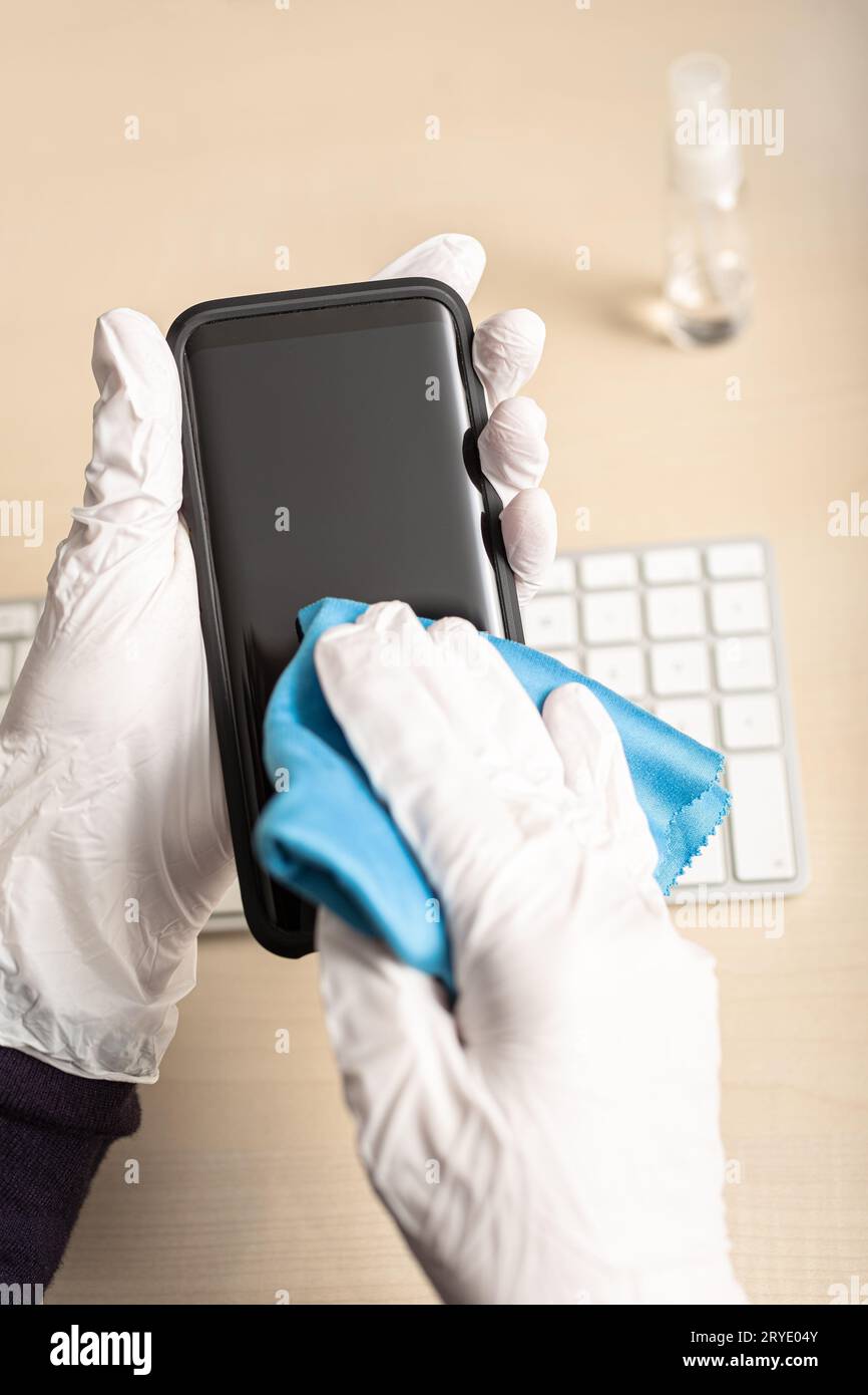 Hands with glove cleaning mobile phone with disinfectant Stock Photo ...