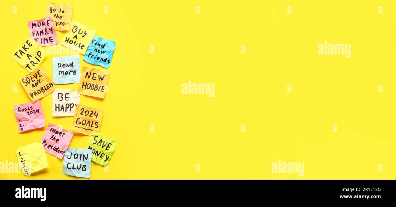 Note papers with written goals for new year 2024 on yellow background ...