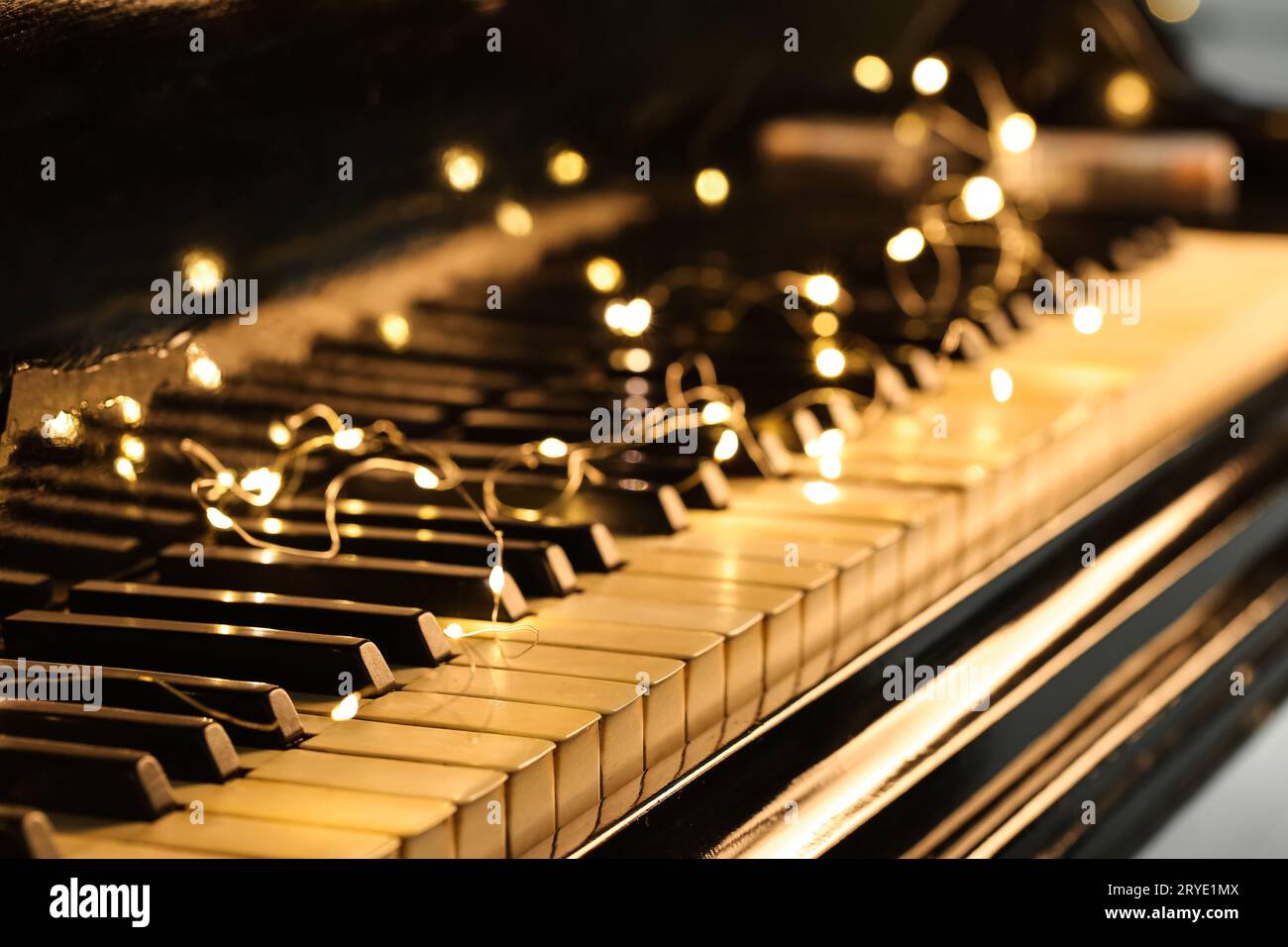 Piano keys with glowing Christmas lights, closeup Stock Photo - Alamy