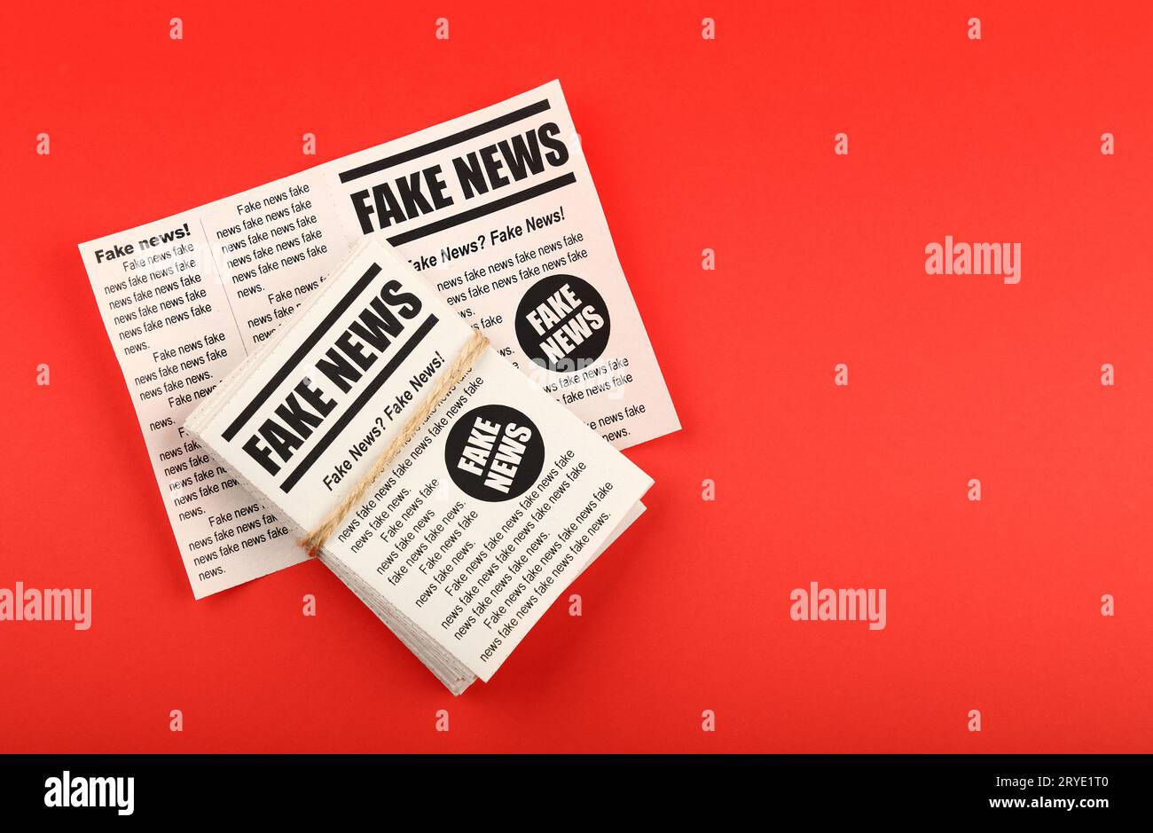 Stack of FAKE NEWS newspapers over red Stock Photo - Alamy