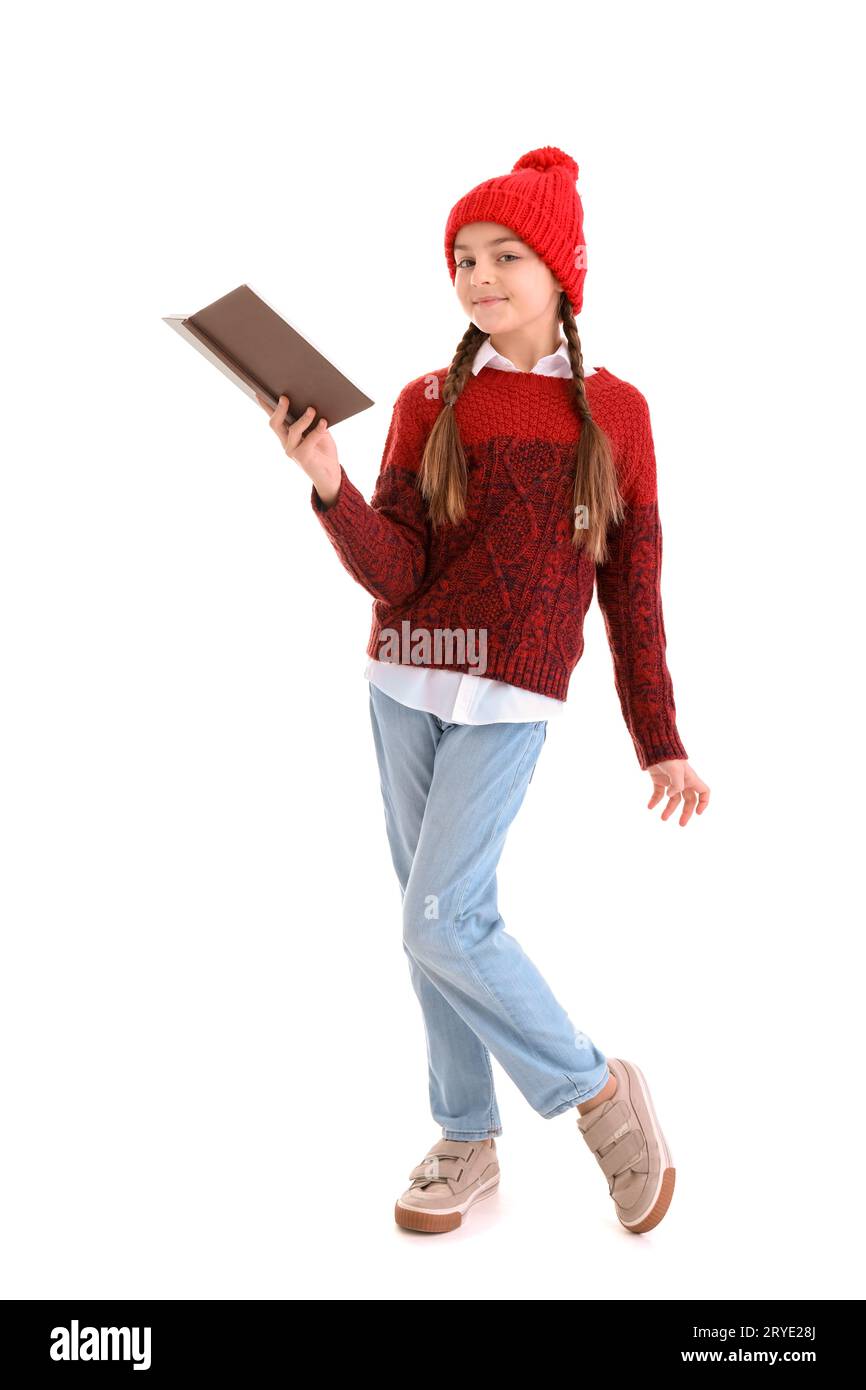 Little girl in winter clothes reading book on white background Stock ...
