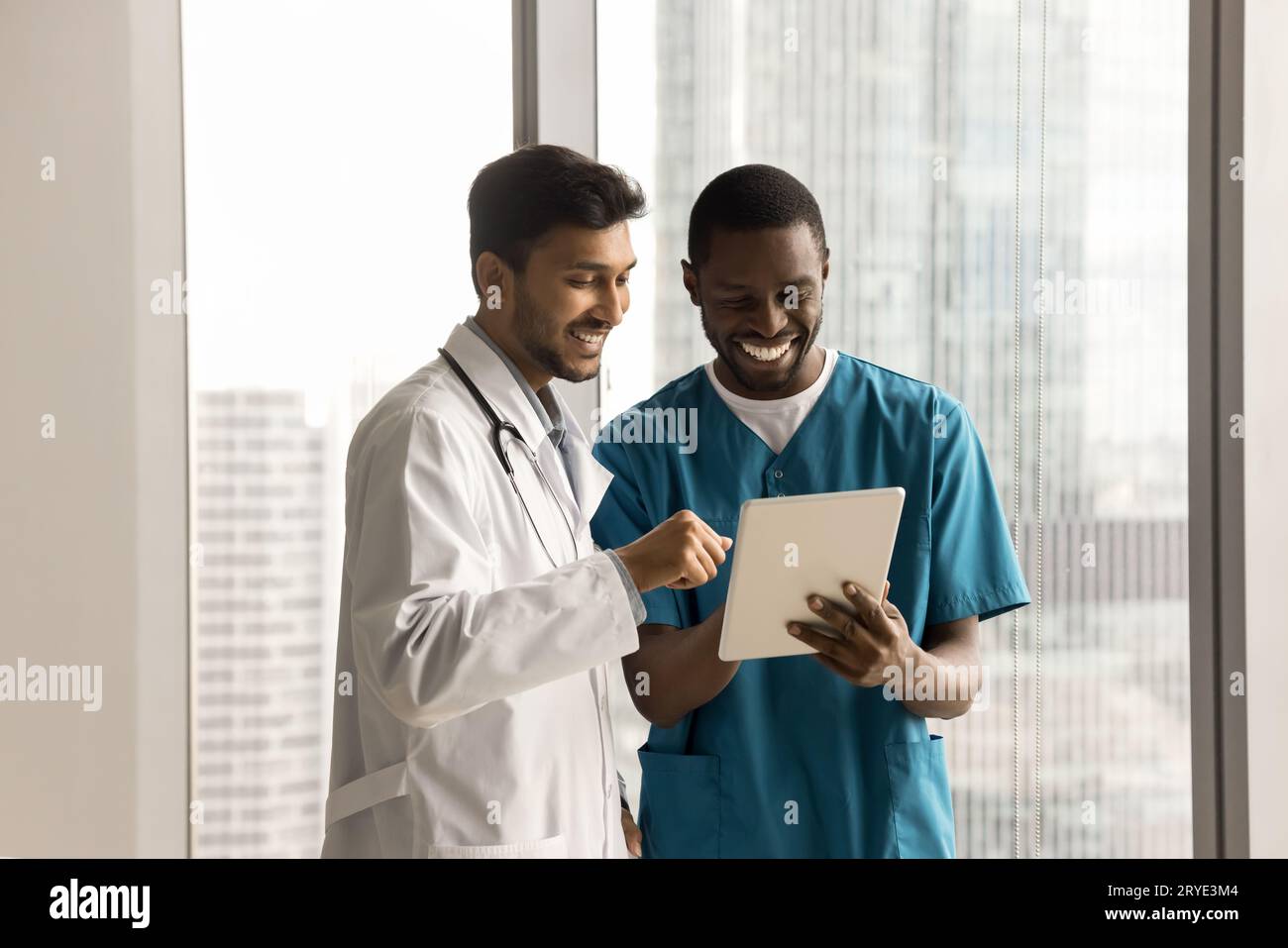 Two happy diverse doctors using tablet for healthcare discussion Stock ...