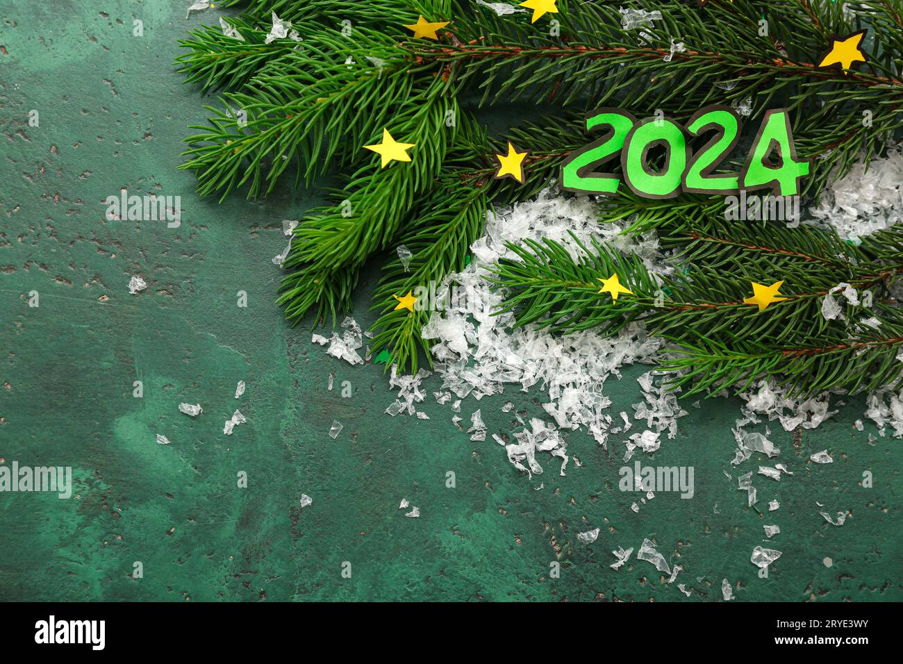 Composition with fir branches, paper numbers 2024 and snow on green ...