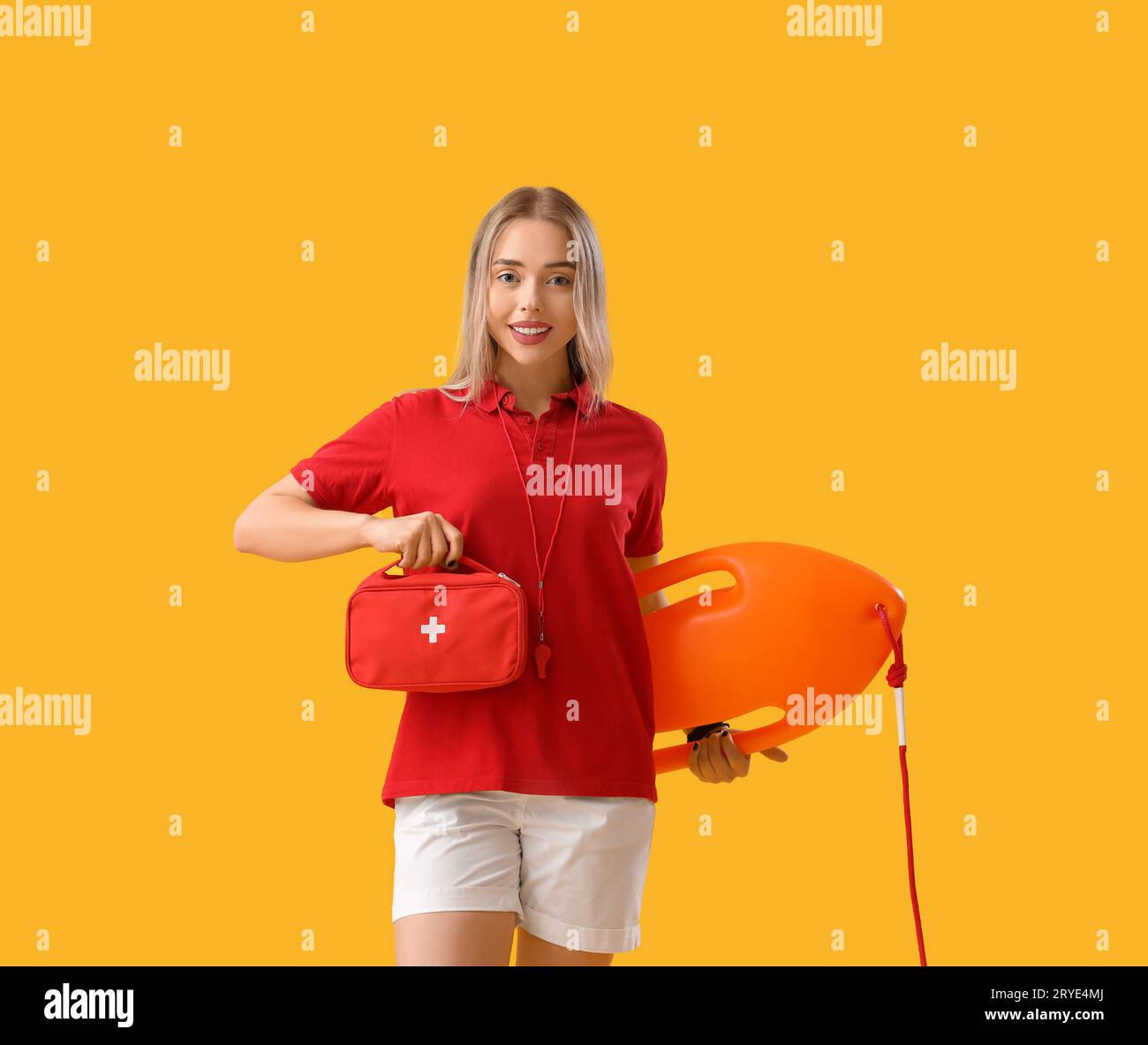 Female lifeguard with rescue buoy and first aid kit on yellow ...
