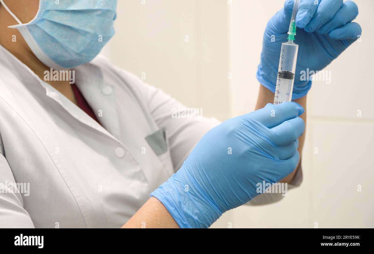 Doctor prepares syringe injection close hi-res stock photography and ...