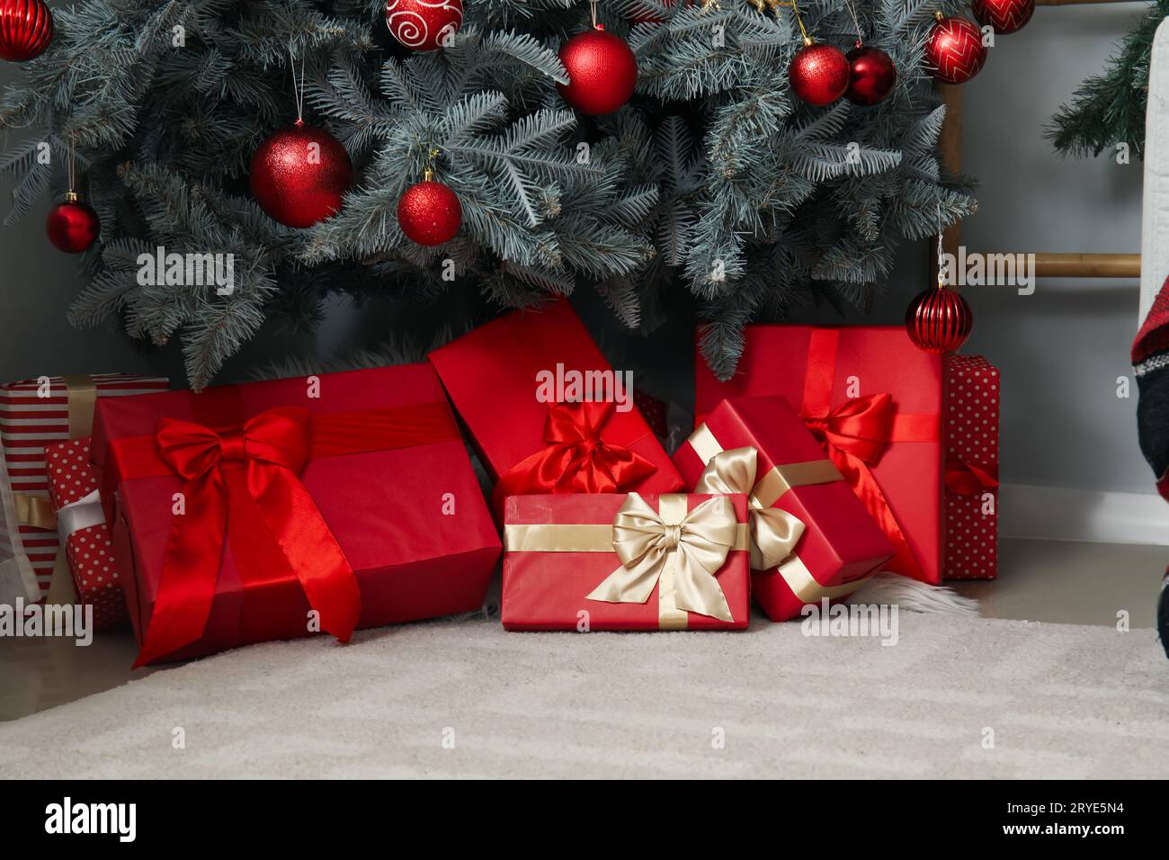 Gift boxes under Christmas tree in living room Stock Photo - Alamy