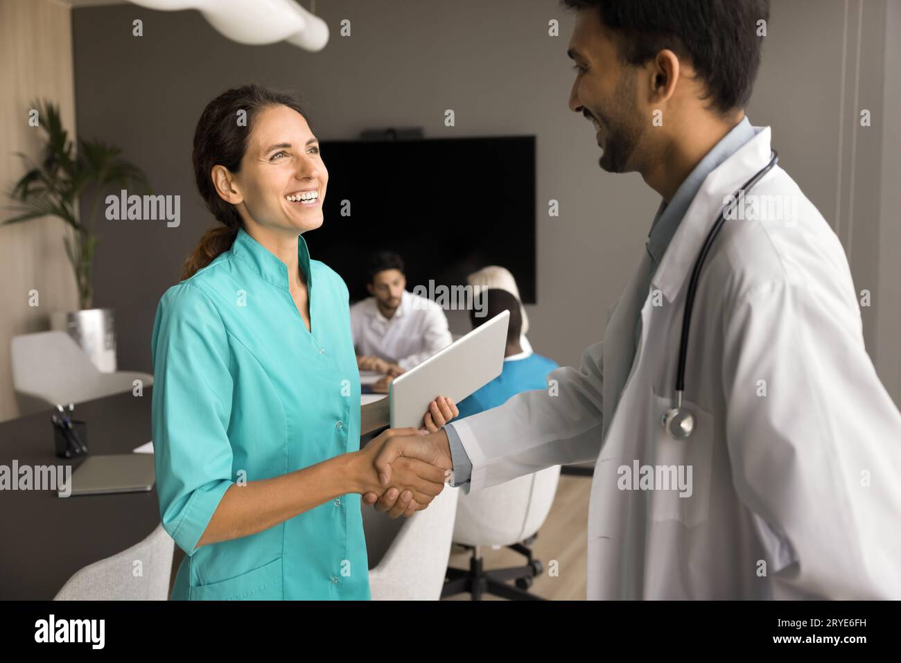 Clinic staff boss giving handshake to happy surgeon with respect Stock ...