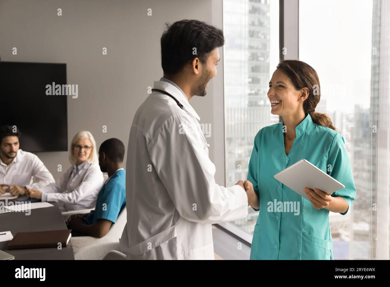 Positive young medical colleagues shaking hands in meeting room Stock ...