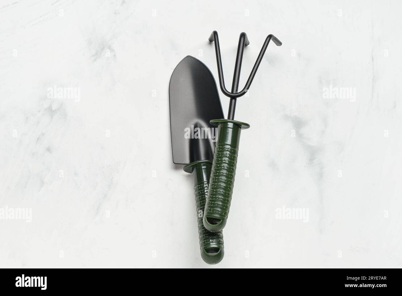Gardening rake and shovel on white marble background Stock Photo - Alamy