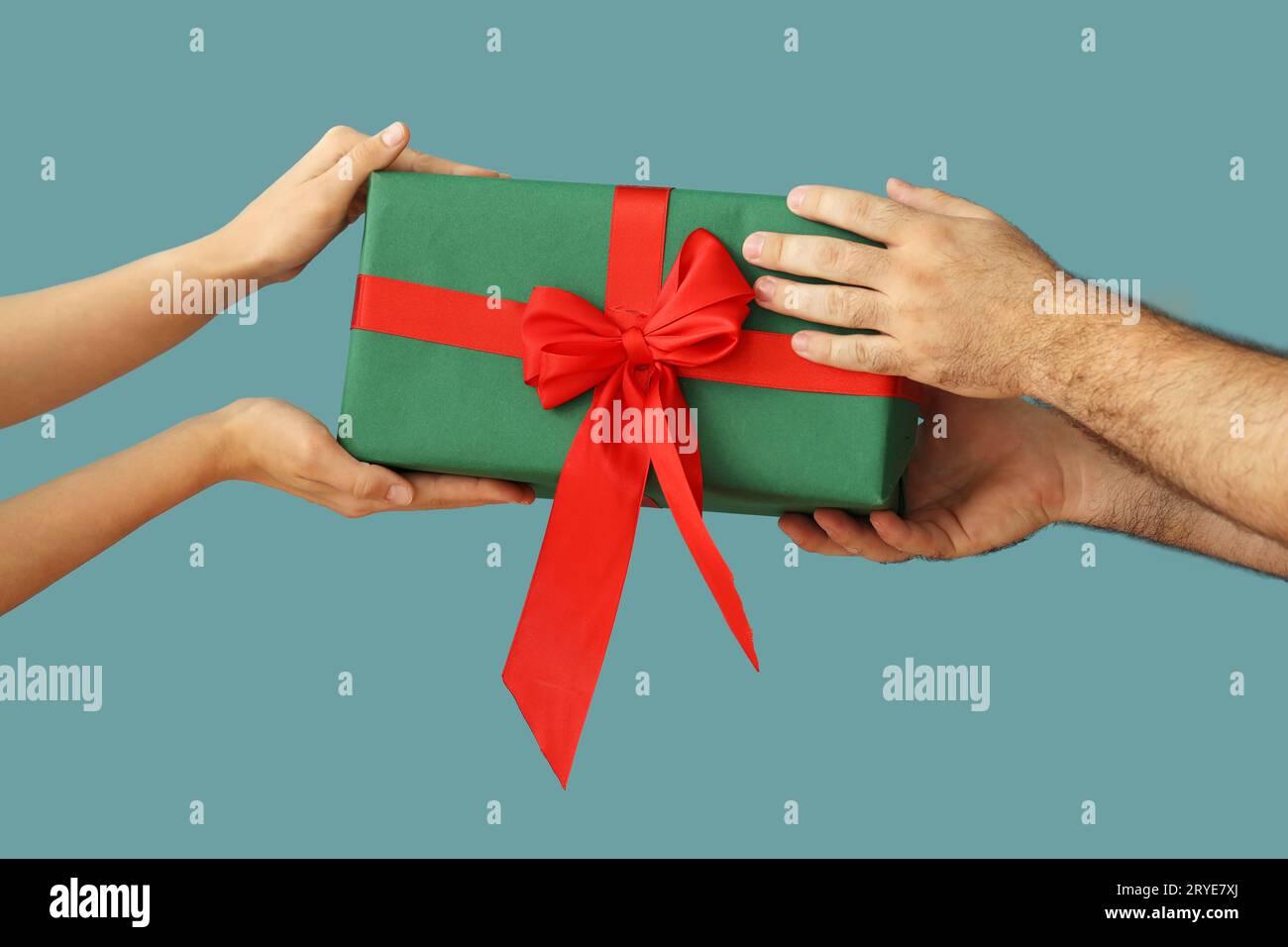 Woman receiving Christmas gift from her friend on blue background Stock ...