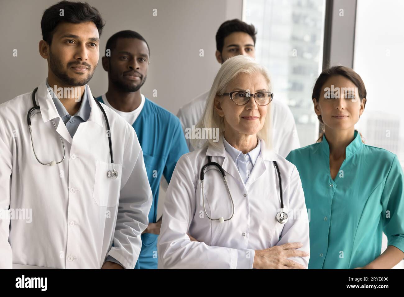 Multiethnic different aged group of doctors standing together for ...