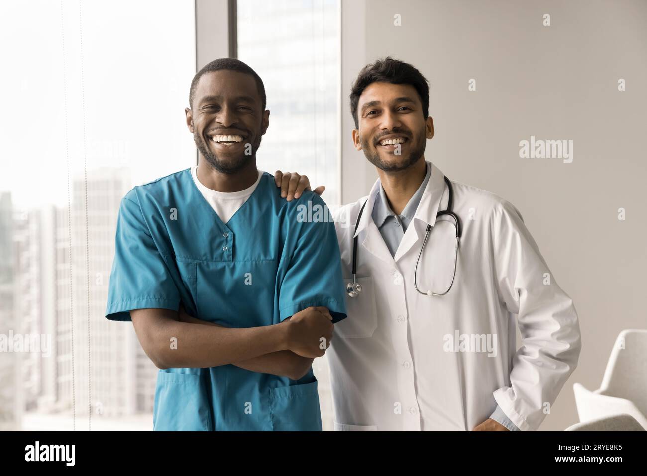 Cheerful handsome diverse doctors posing for portrait indoors Stock ...