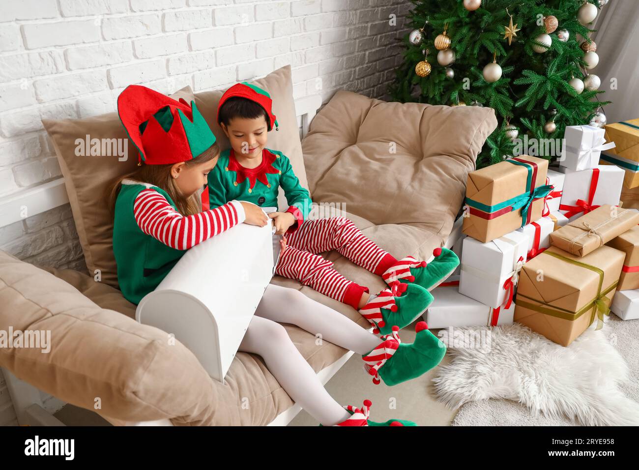 Cute little children dressed as elves with mailbox at home on Christmas ...