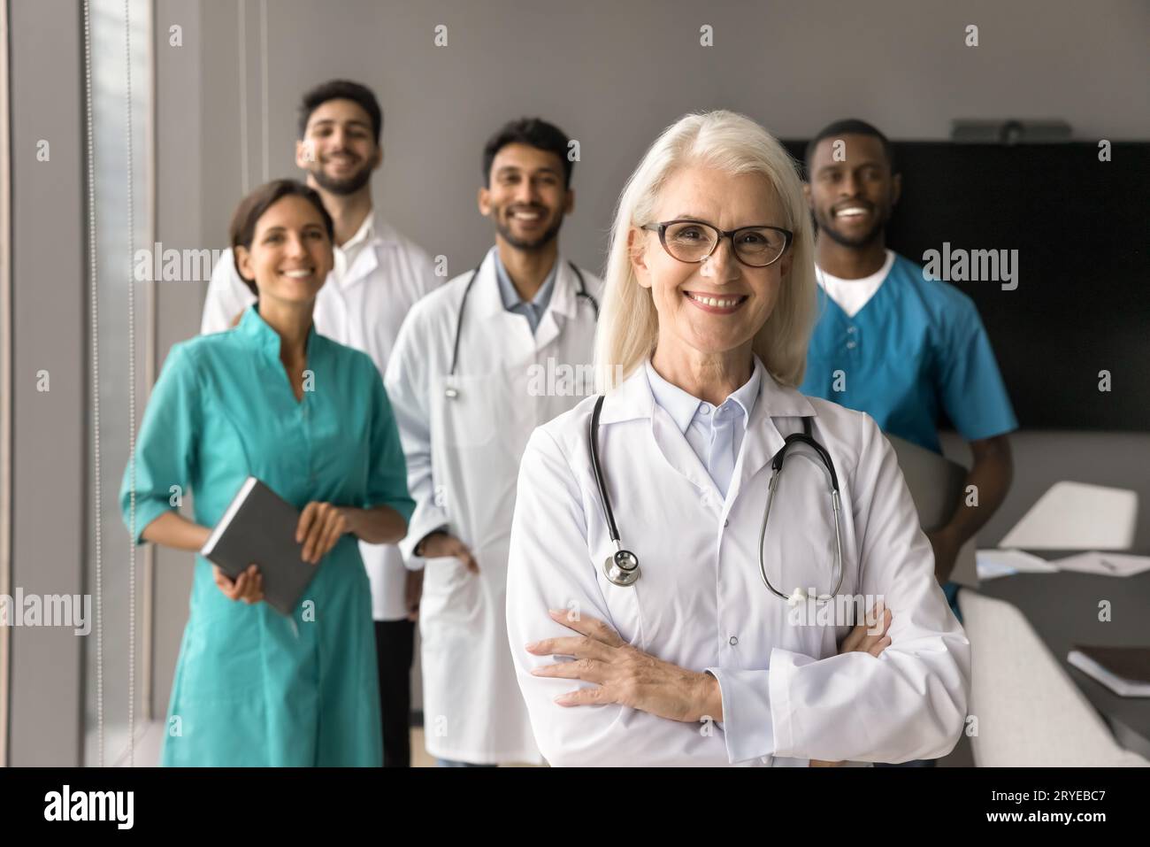 Happy elder mature head doctor woman posing with arms crossed Stock ...
