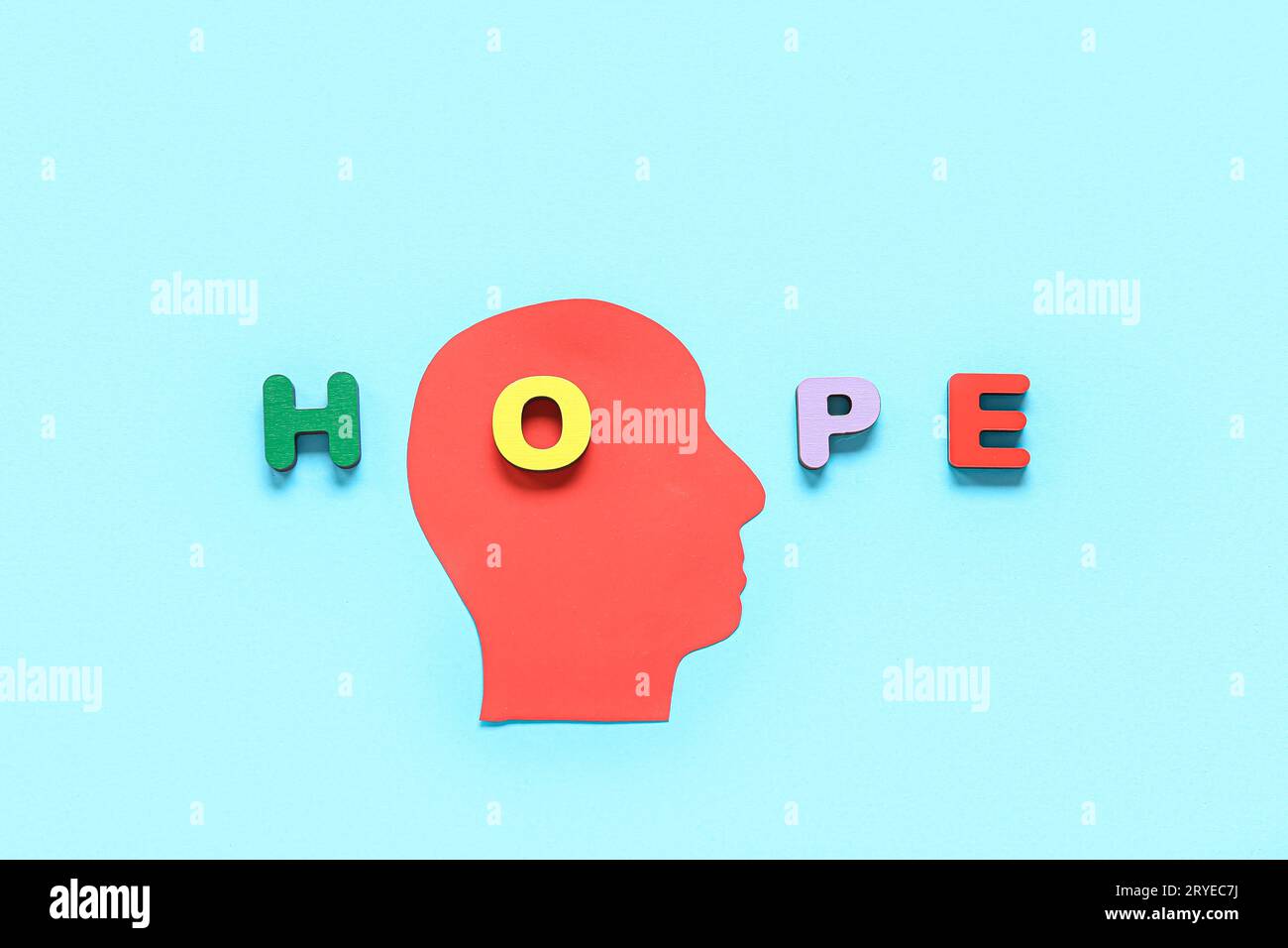 Paper human head and word HOPE made of wooden letters on blue ...