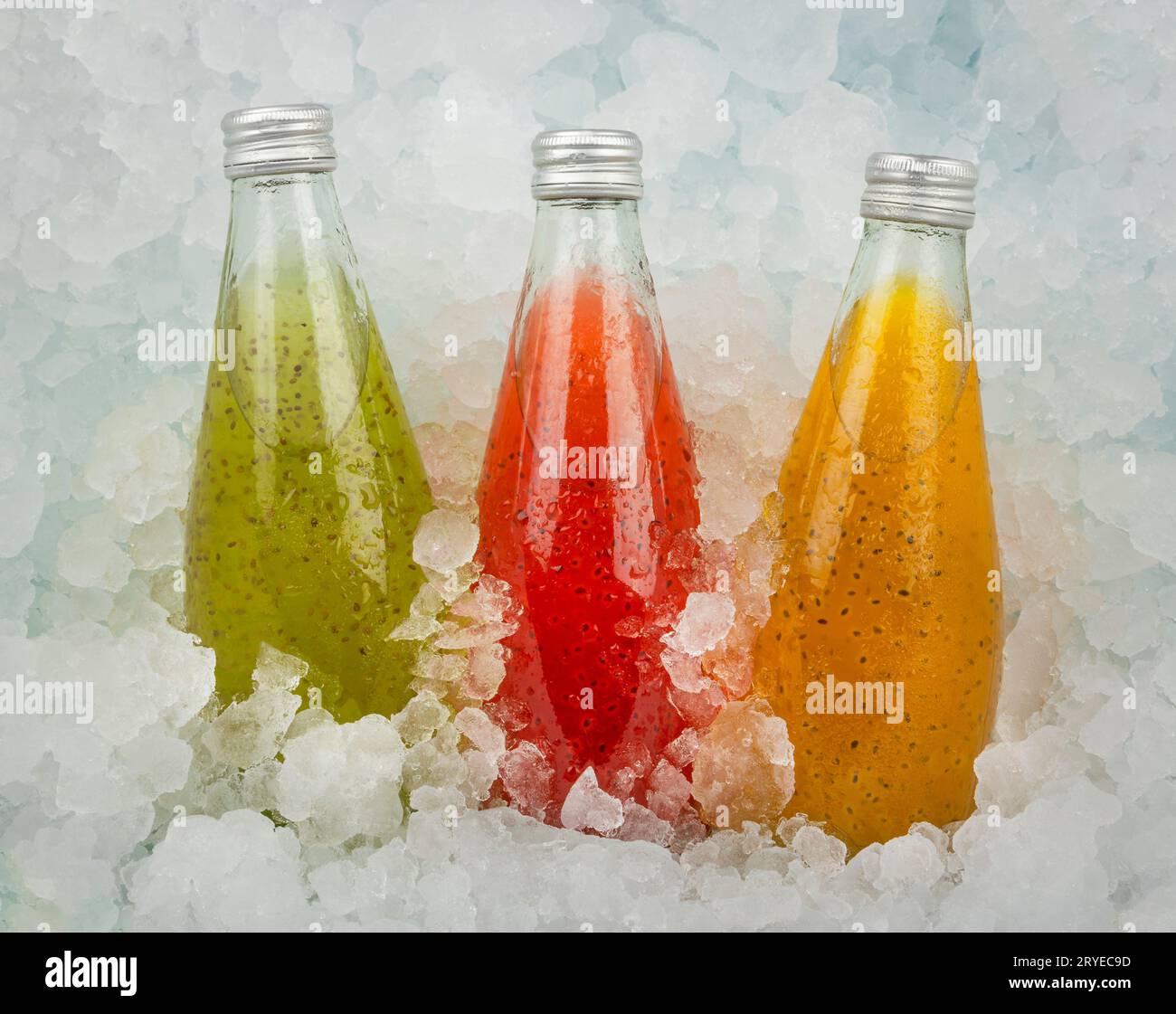 Three bottles of fruit juice drinks on ice Stock Photo - Alamy