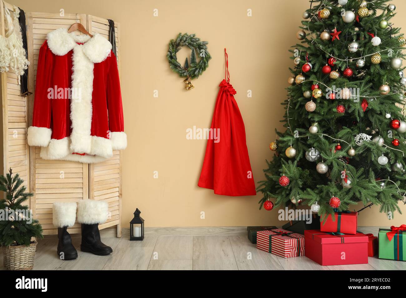Interior of room with Santa costume and Christmas tree Stock Photo - Alamy