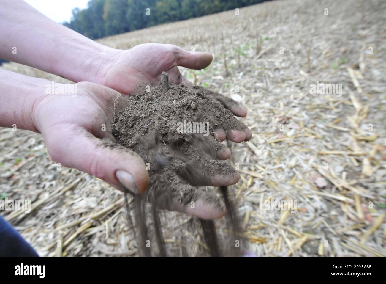 Dry soil running through farmers hands Stock Photo - Alamy