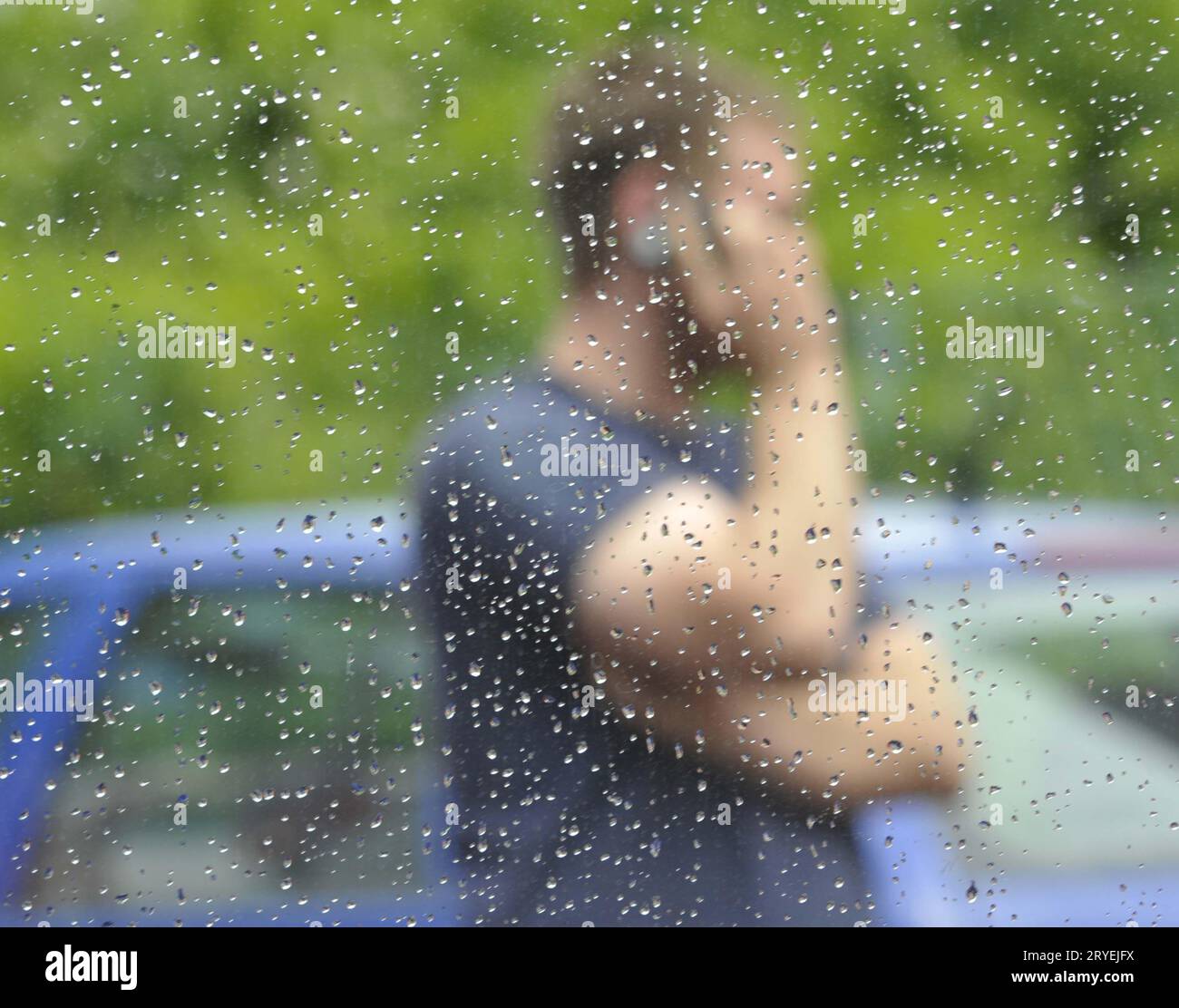 Rain drops on a window and person Stock Photo - Alamy