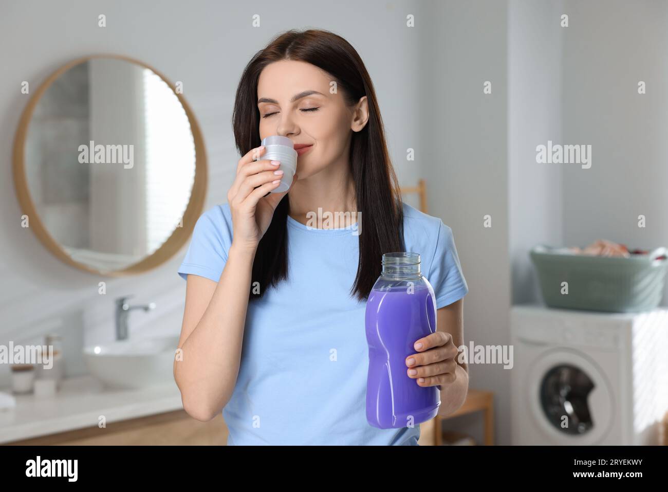 Beautiful woman smelling fabric softener in bathroom Stock Photo - Alamy