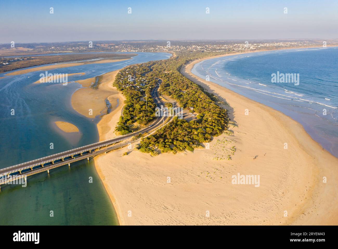 Aerial view of twin bridges crossing a coastal river and winding ...