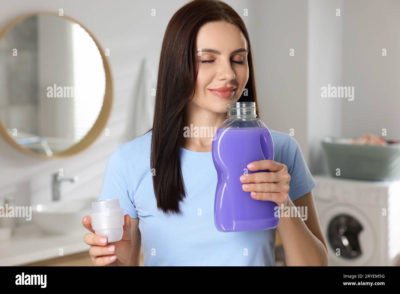 Beautiful woman smelling fabric softener in bathroom Stock Photo - Alamy