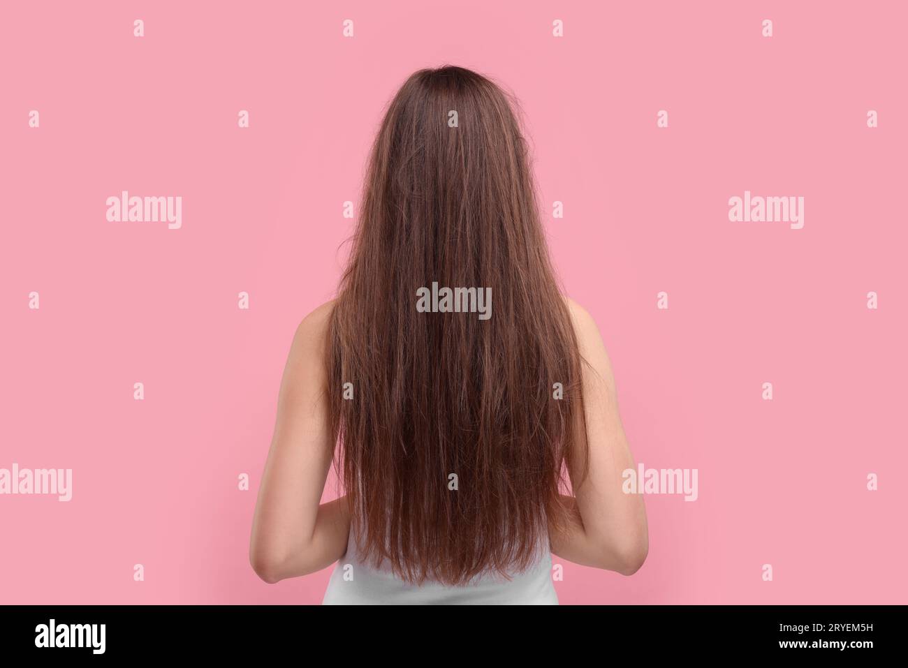 Woman with damaged messy hair on pink background, back view Stock Photo ...