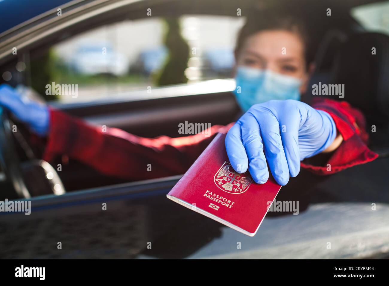 Woman holding red passport through car window Stock Photo - Alamy