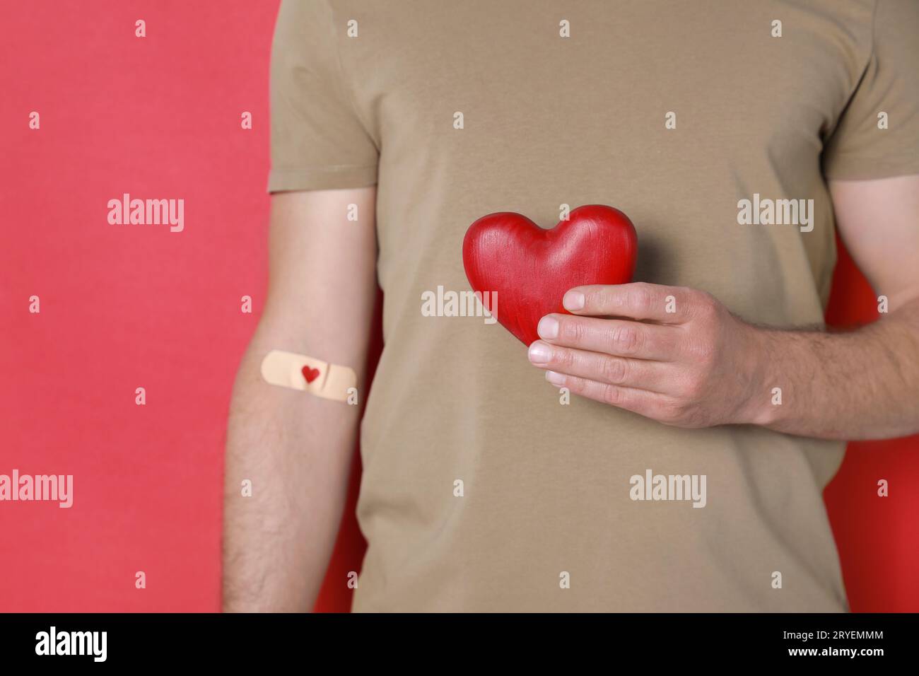 Blood donation concept. Man with adhesive plaster on arm holding red ...