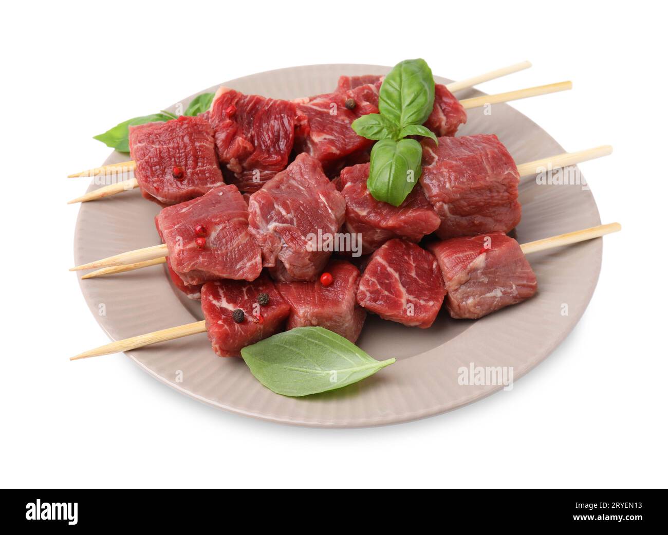 Wooden skewers with cut fresh beef meat, basil leaves and spices ...
