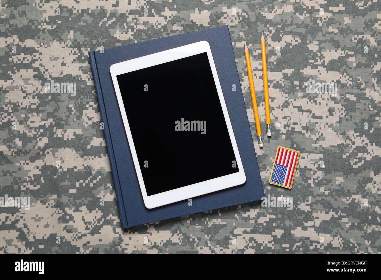 Notebook, tablet, pencils and patch on camouflage background, flat lay ...