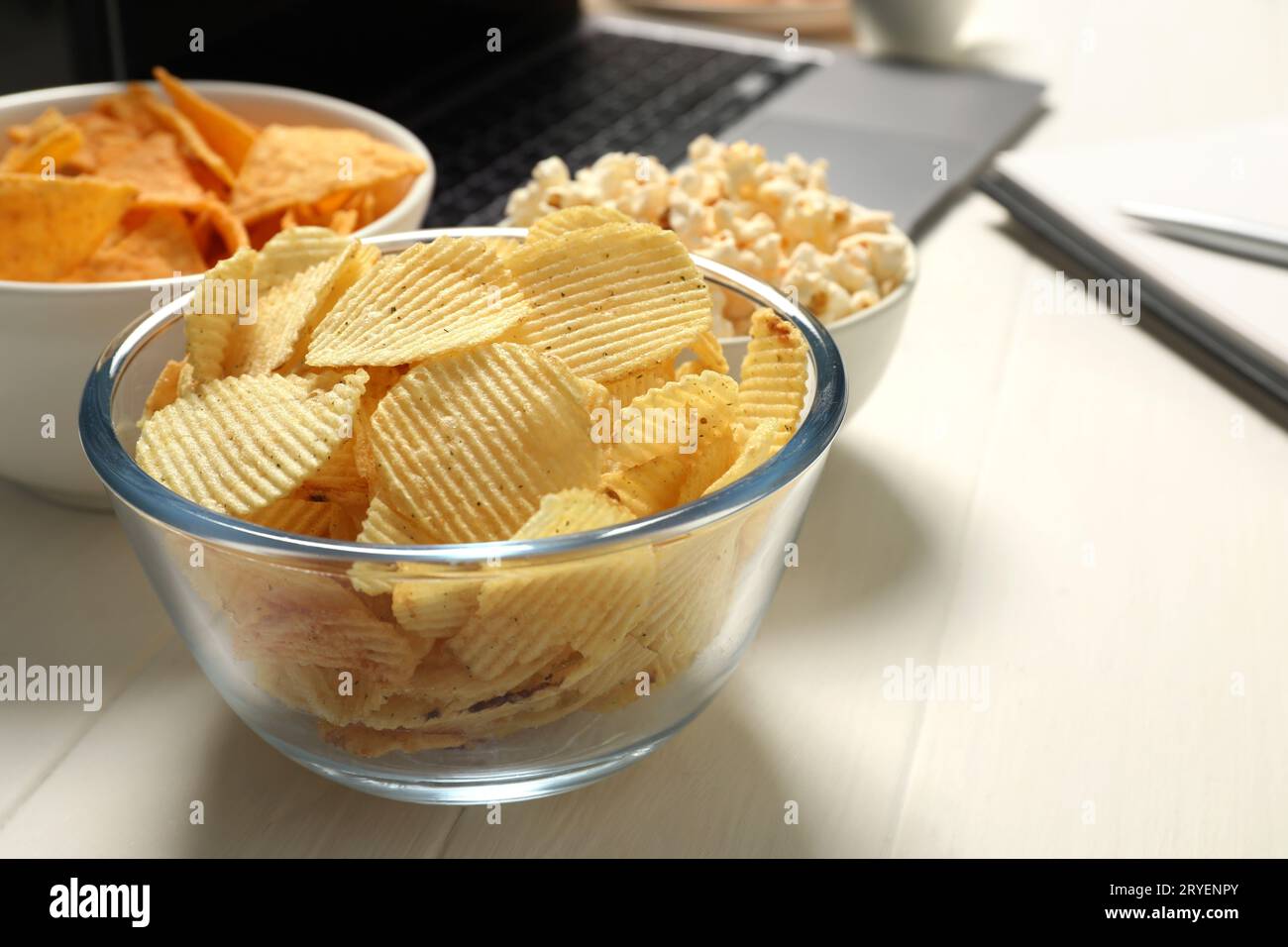 Bad eating habits at workplace. Different snacks on white wooden table ...