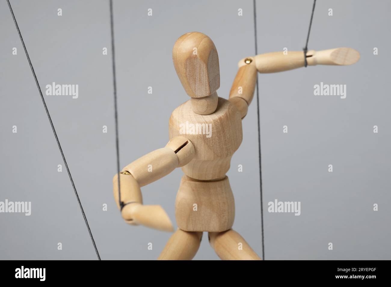 One wooden puppet with strings on light grey background Stock Photo - Alamy