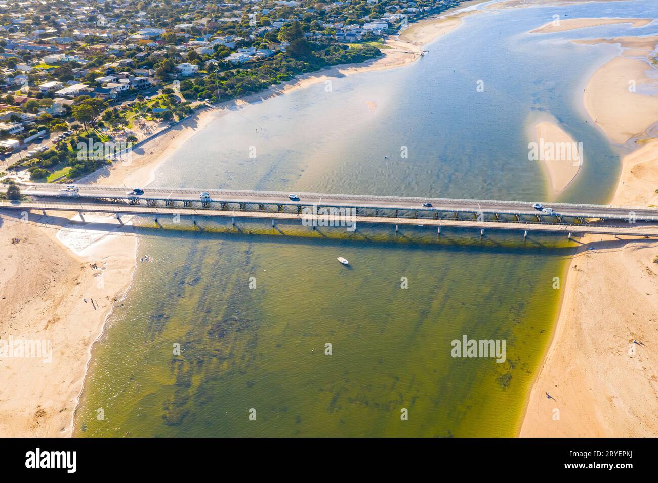 Aerial view of twin bridges over a wide coastal river with beaches on ...