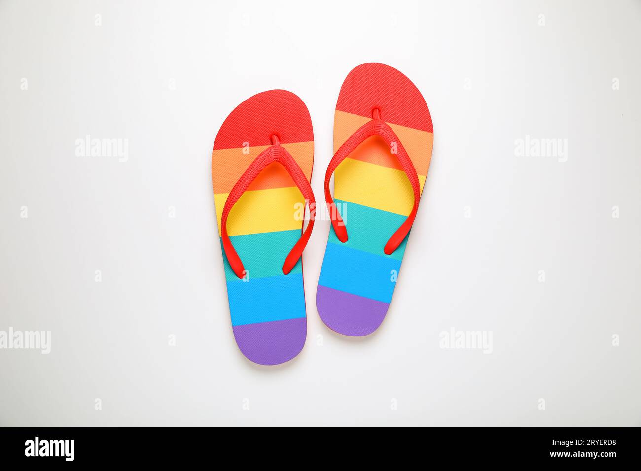 Stylish rainbow flip flops on white background, top view Stock Photo ...