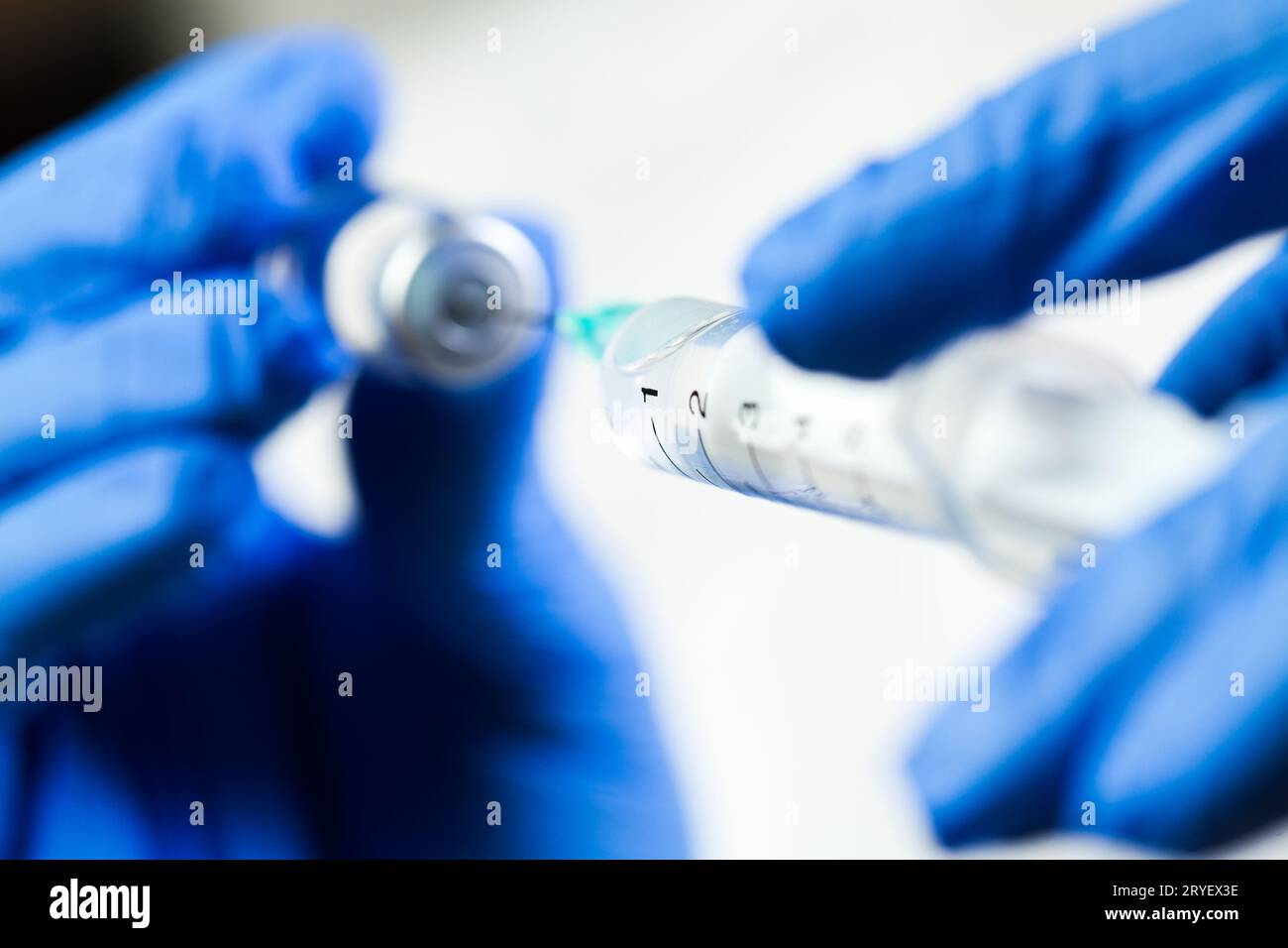 Medical syringe needle drawing vaccine shot from glass ampoule bottle ...