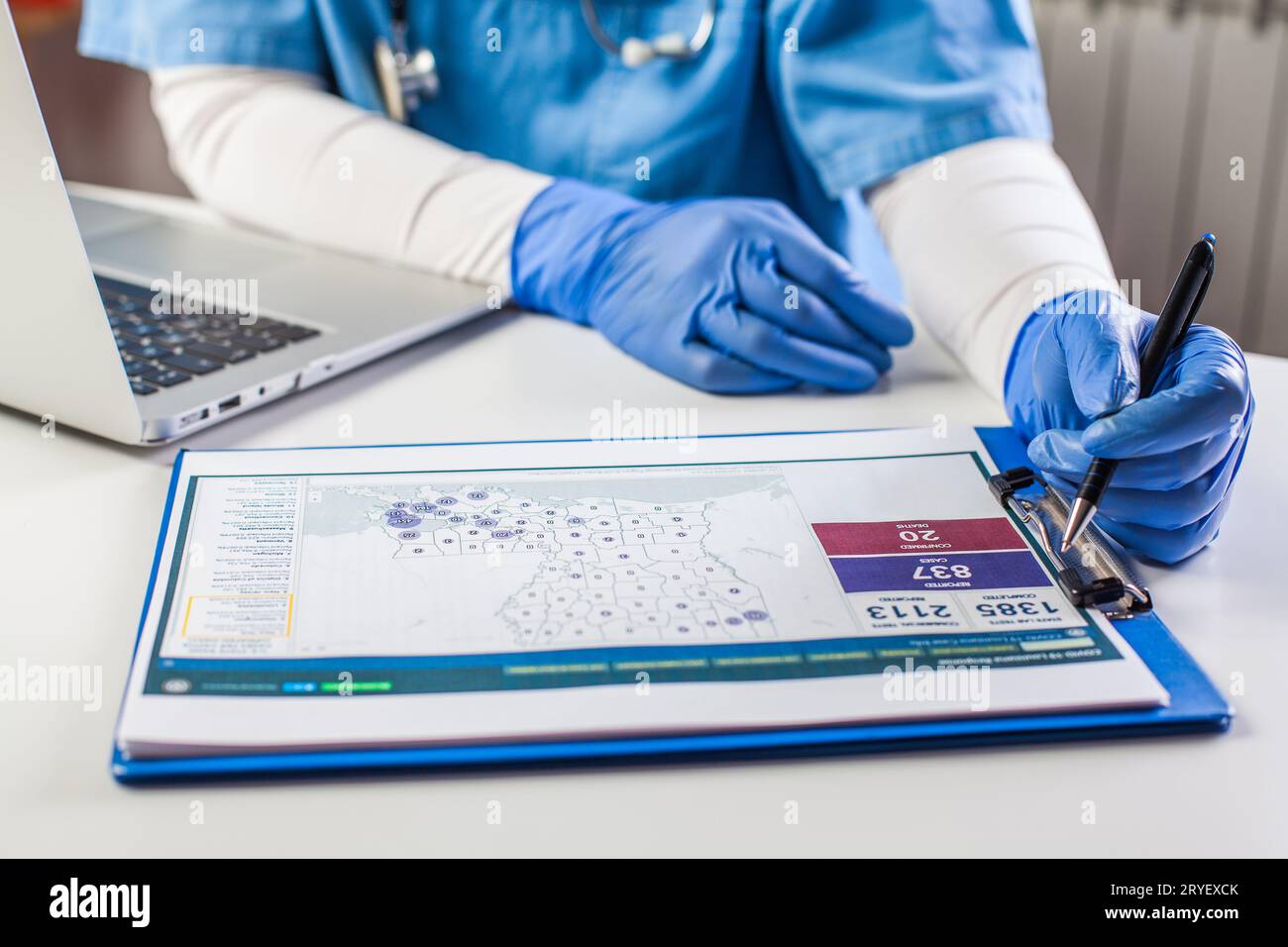 Doctor wearing protective gloves working on laptop computer Stock Photo ...