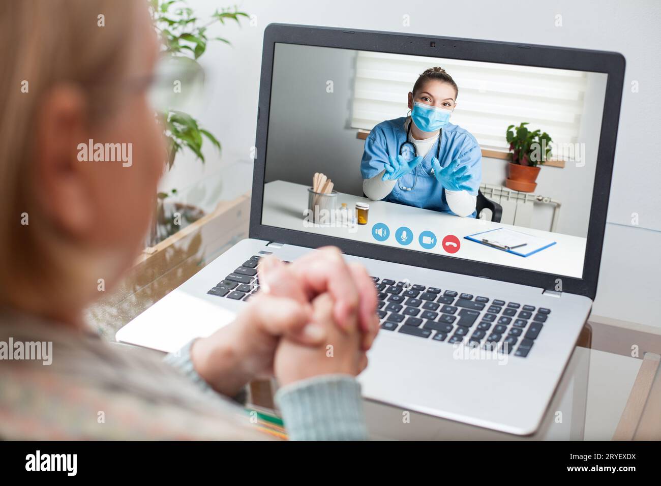 Young GP physician and elderly female patient consulting over video ...
