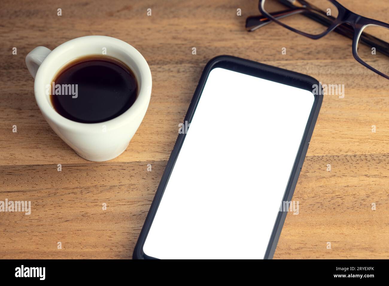 Smart phone on desk with white screen, eyeglasses and cup of coffee on ...