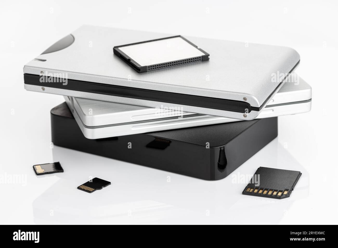 Group of external Hard disks and memory cards on white table. Data ...
