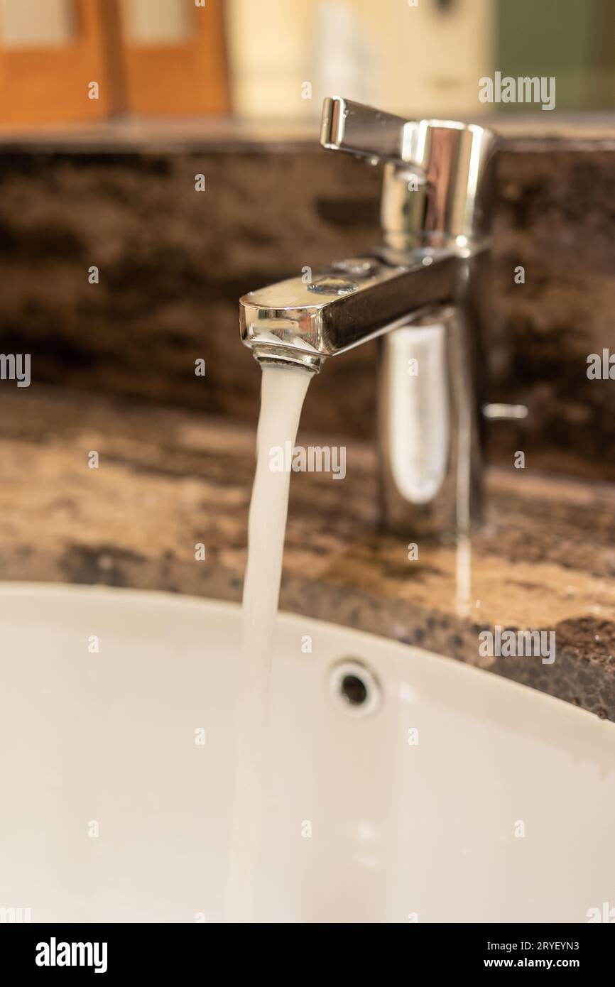 Water running from a toilet sink tap Stock Photo - Alamy