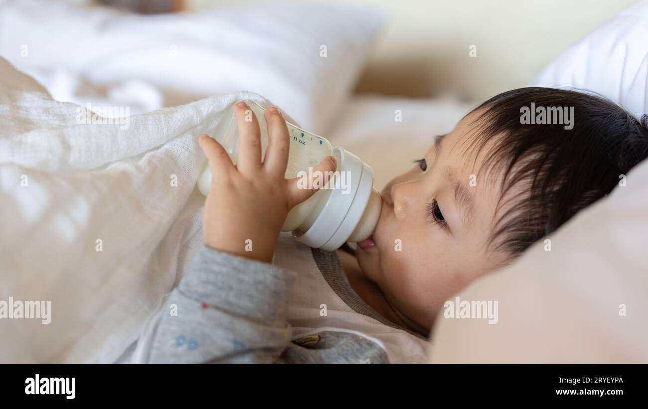Asian Chinese baby boy age 1 to 2 drinking milk with holding milk ...